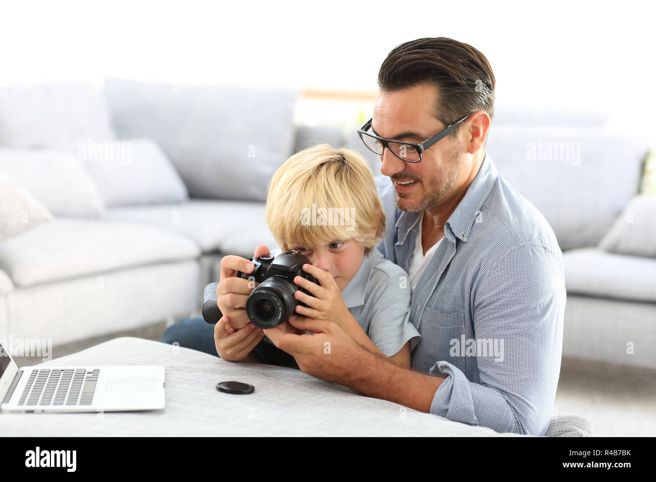 Man with little boy playing with reflex camera Stock Photo - Alamy