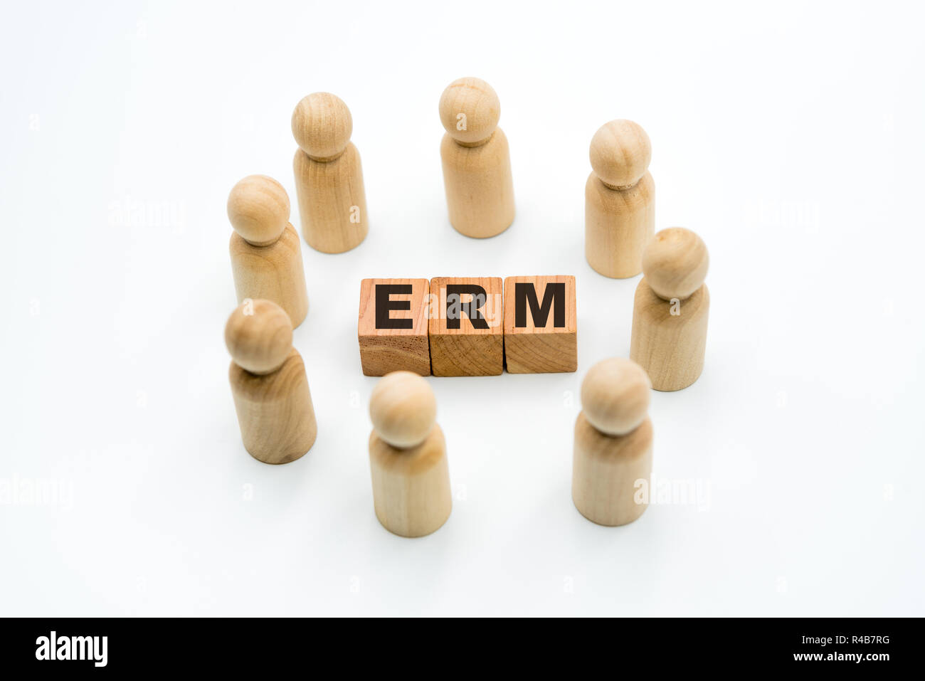 Wooden figures as business team in circle around acronym ERM Enterprise ...