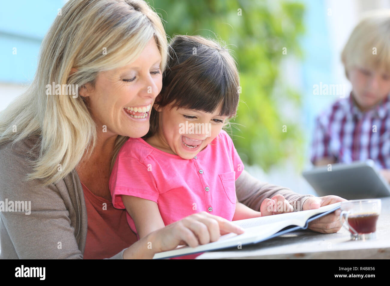 Woman with daughter teaching how to read Stock Photo - Alamy