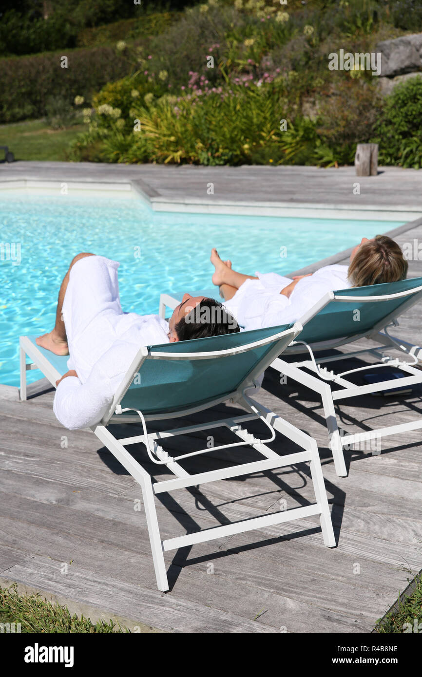 Couple in luxury spa hotel relaxing by pool Stock Photo - Alamy