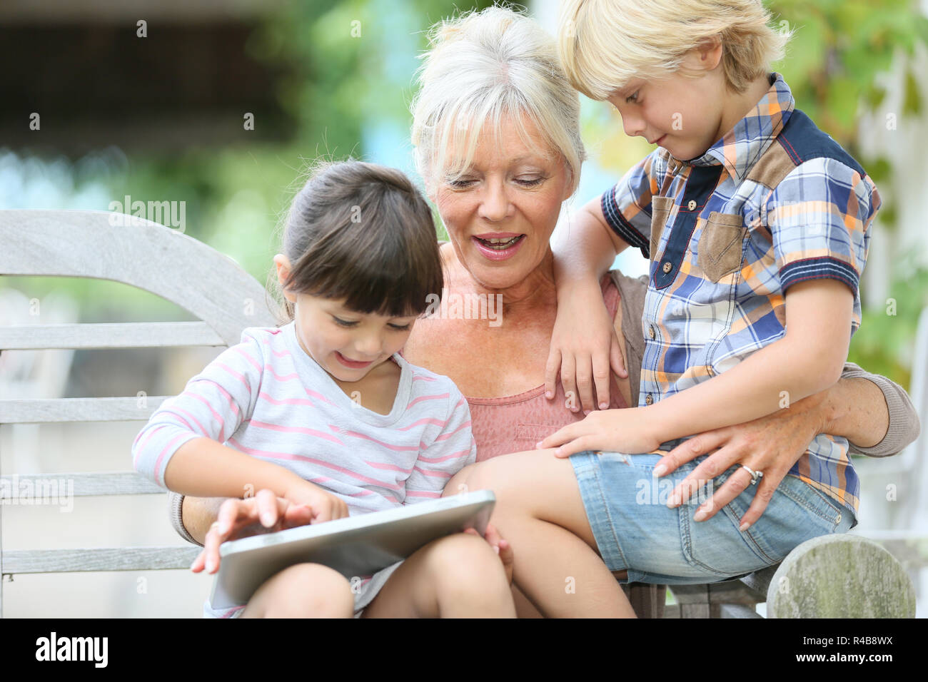 Grandmother with kids playing games on tablet Stock Photo - Alamy