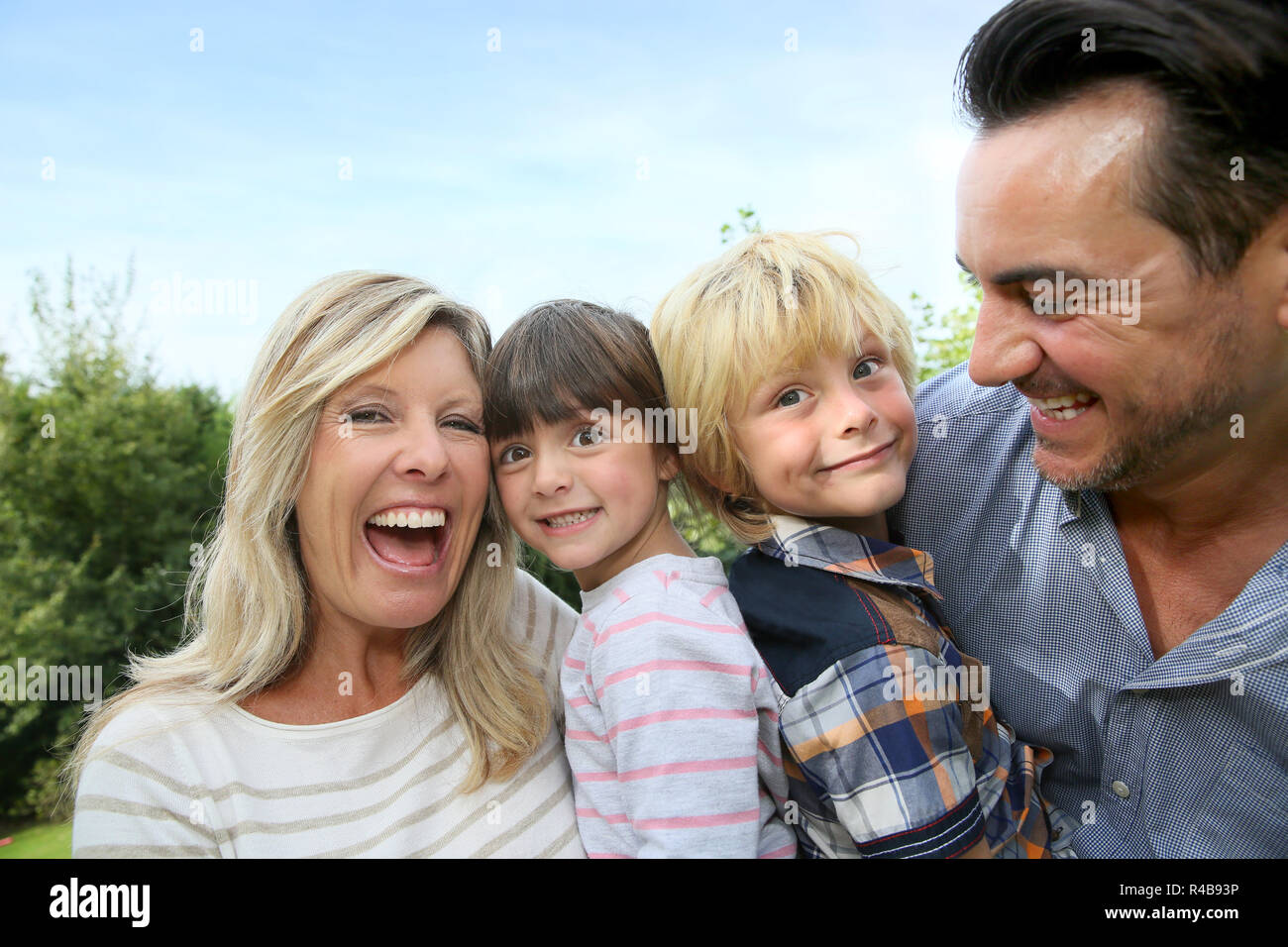 Happy family of four having fun outside Stock Photo - Alamy
