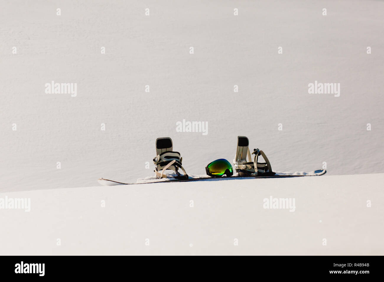 Snowboard and ski googles laying on a snow near the freeride slope ...