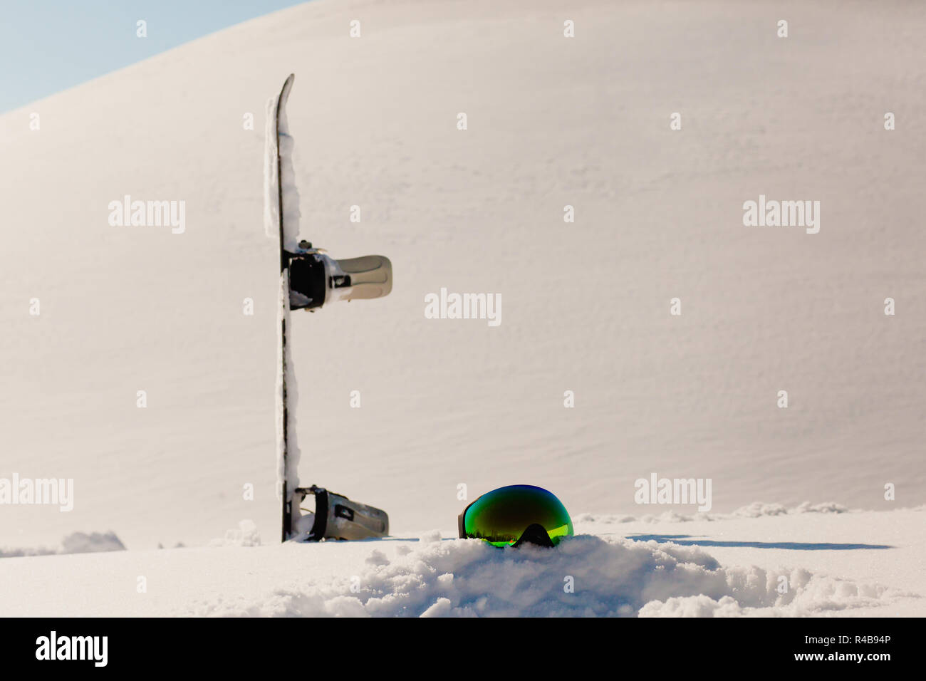 Snowboard and ski googles laying on a snow near the freeride slope ...