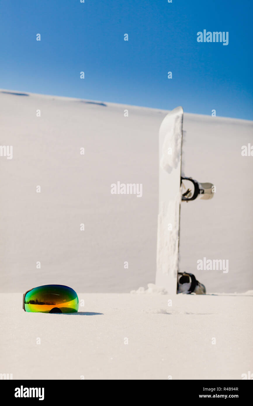 Snowboard and ski googles laying on a snow near the freeride slope ...