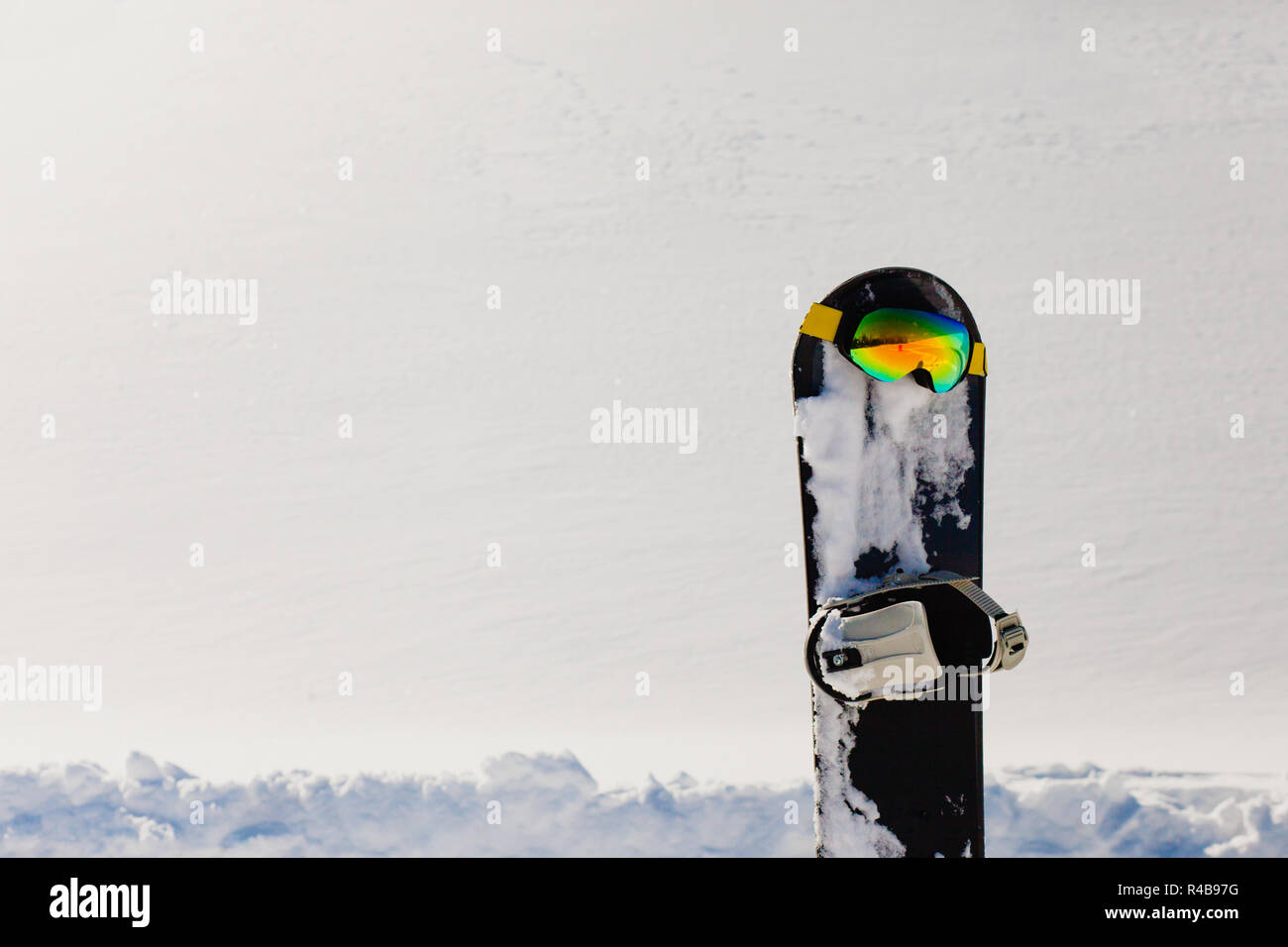Snowboard and ski googles laying on a snow near the freeride slope ...