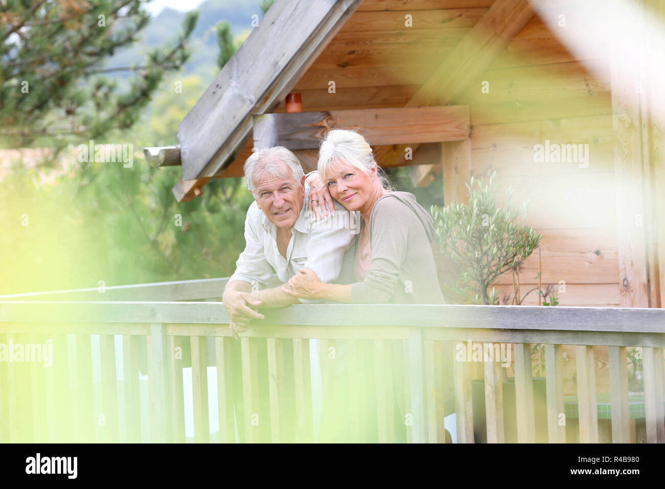 Senior couple standing oustide log cabin in countryside Stock Photo - Alamy