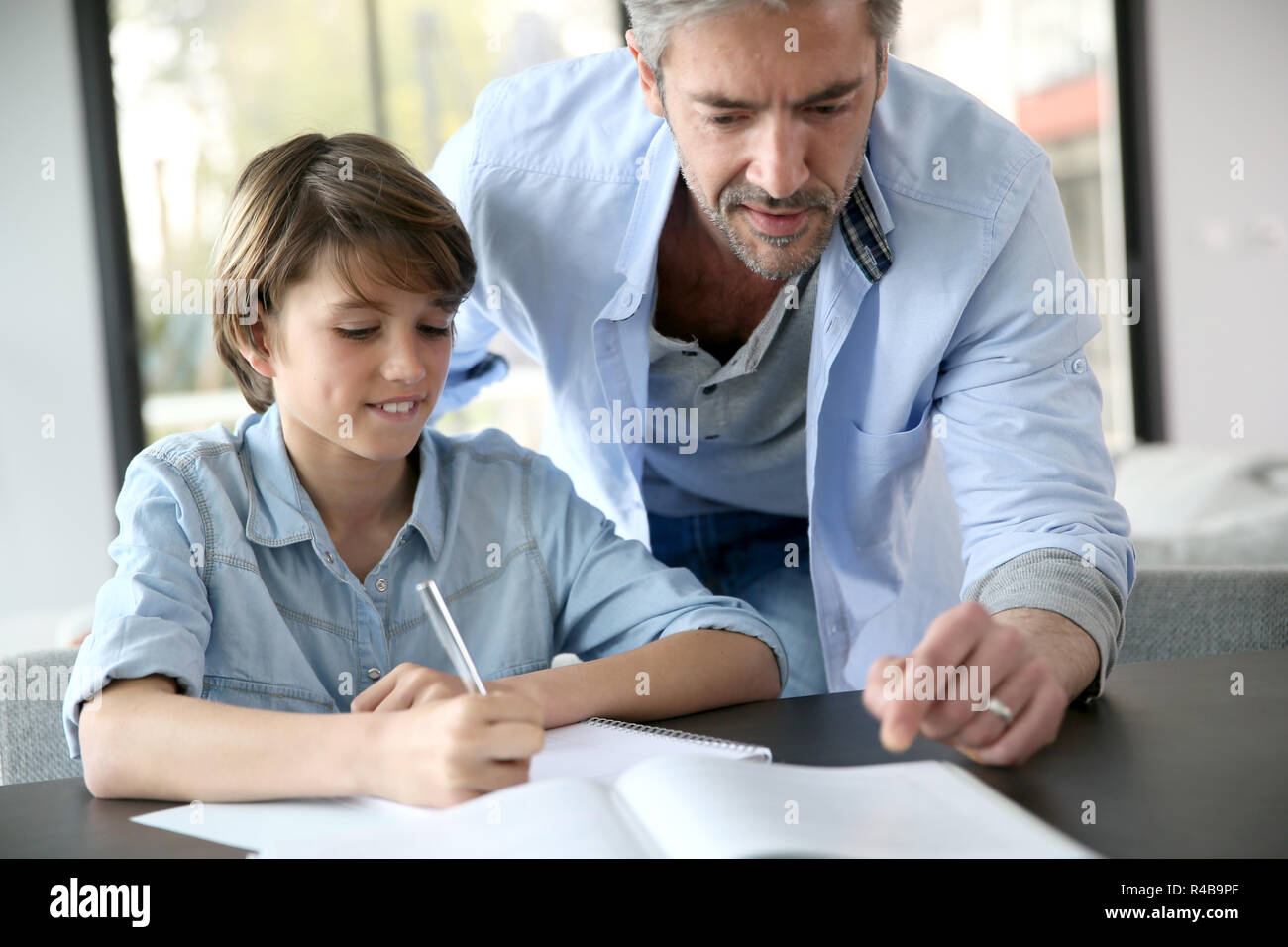Dad helping son write hi-res stock photography and images - Alamy