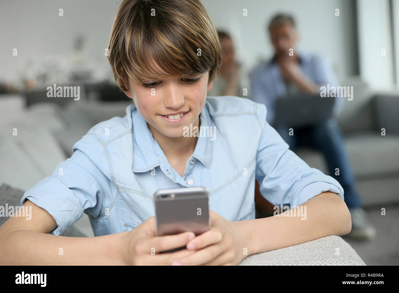 Teenage boy using smartphone at home Stock Photo - Alamy