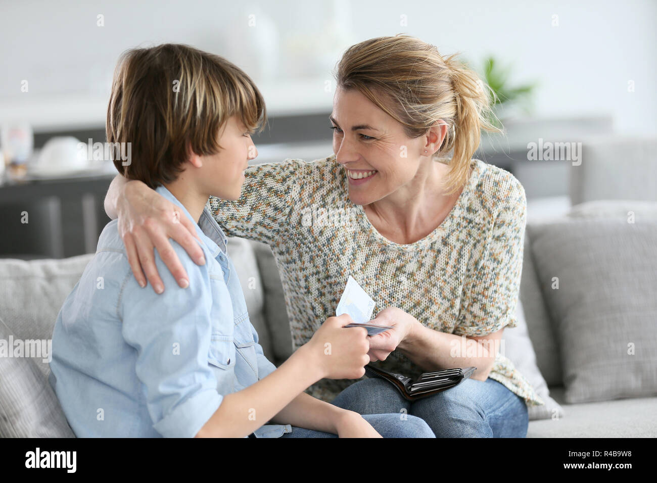 Mother giving money to adolescent for reward Stock Photo - Alamy