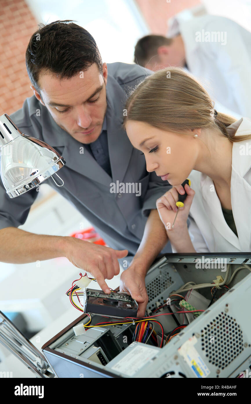 Teacher with student in technology repairing computer Stock Photo - Alamy