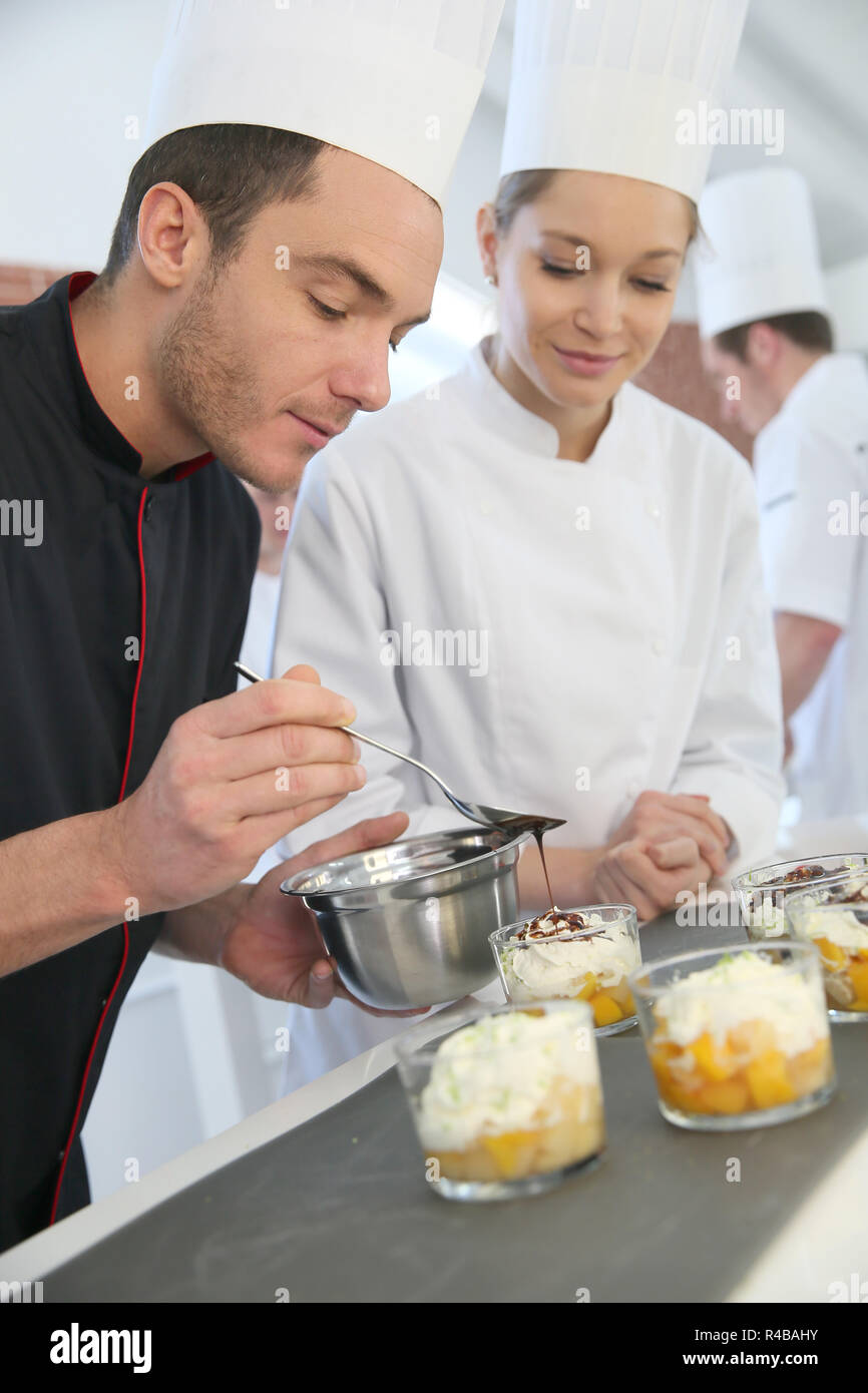 Chef with student in pastry making dessert Stock Photo - Alamy