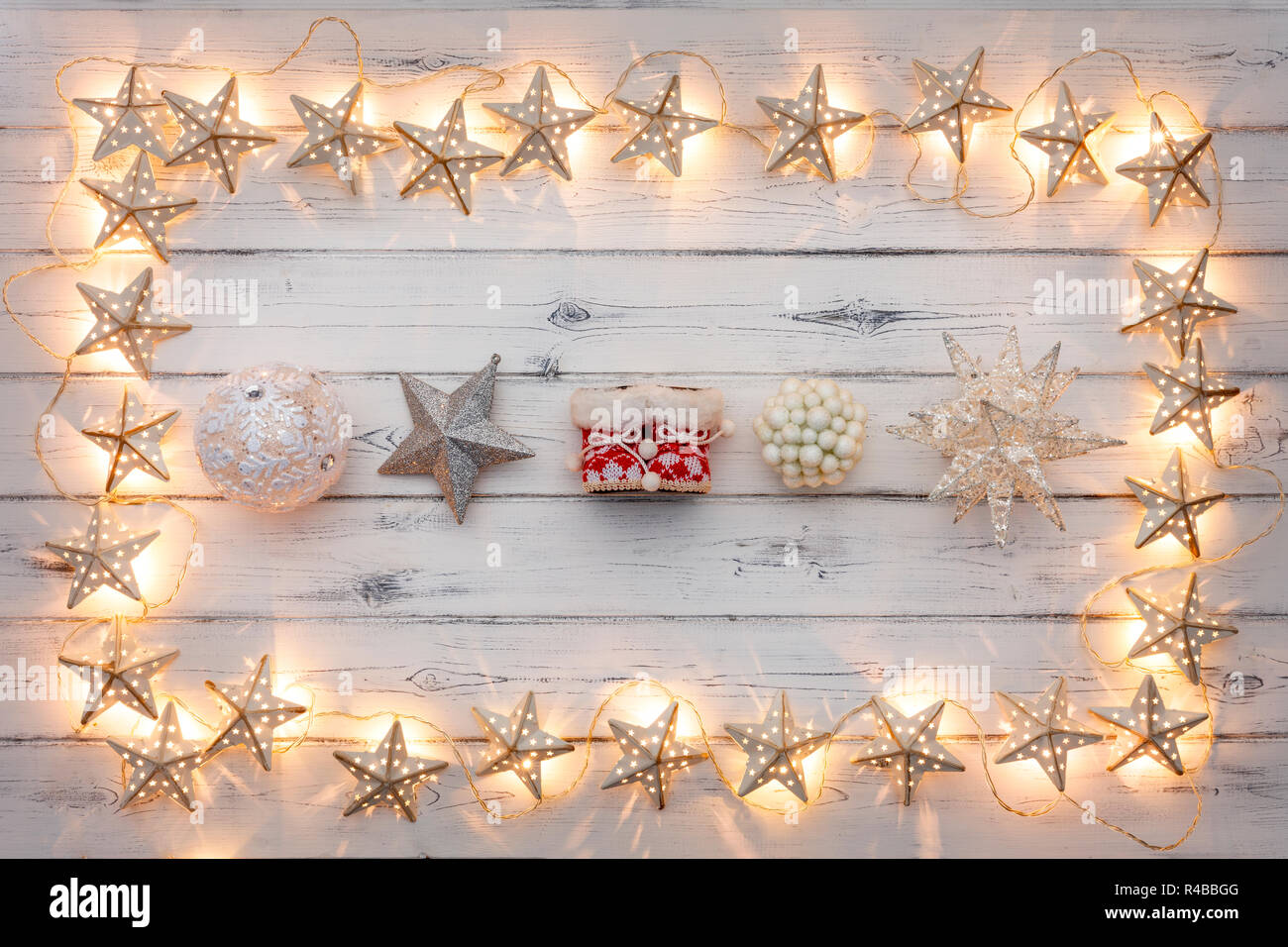 A string of golden star christmas lights, and a row of baubles, on a ...