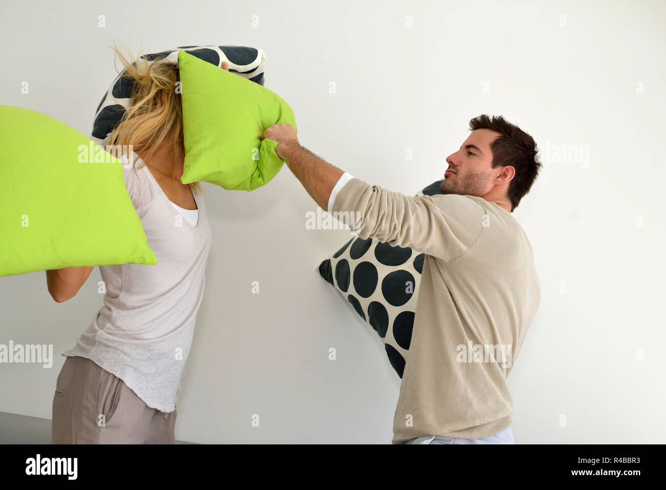 Angry couple throwing pillows at each other Stock Photo - Alamy