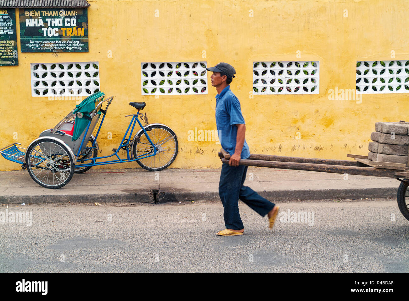 man pulling a heavily loaded cart in a street of Hoi An, Vietnam Stock ...