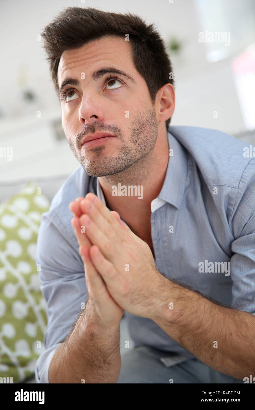Man imploring with hands together Stock Photo - Alamy