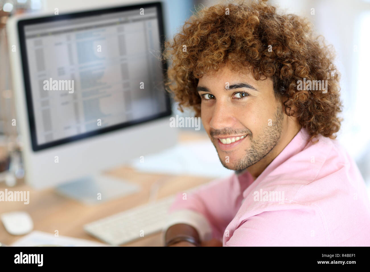 Young man in office working on desktop computer Stock Photo - Alamy
