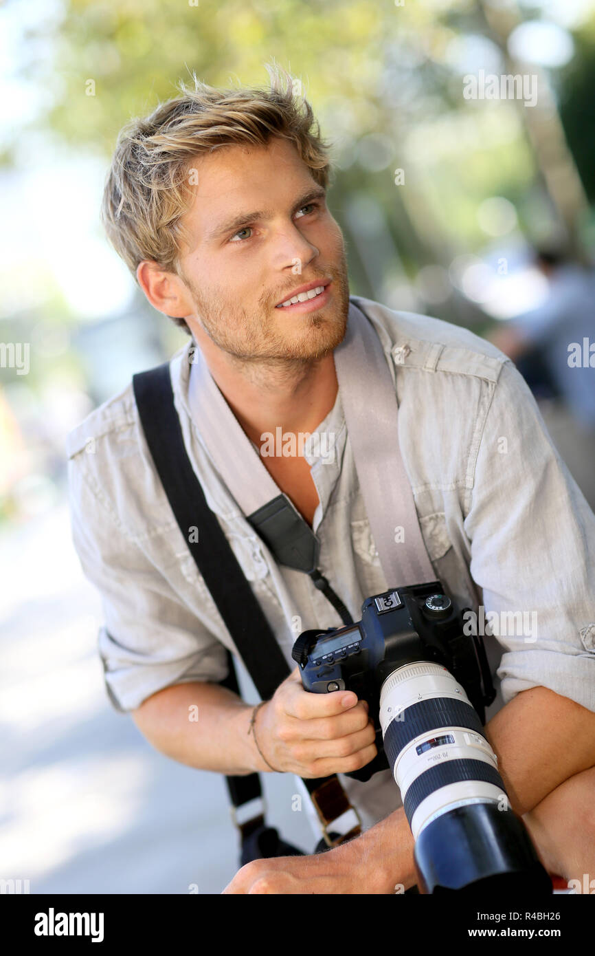 Portrait of handsome photographer holding camera Stock Photo - Alamy