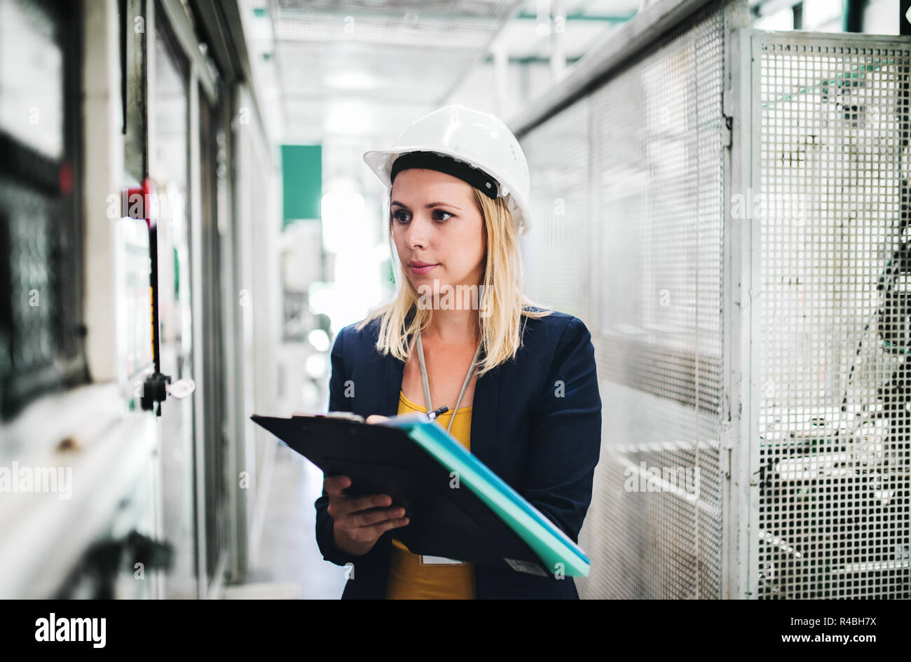 A portrait of an industrial woman engineer in a factory, writing Stock ...