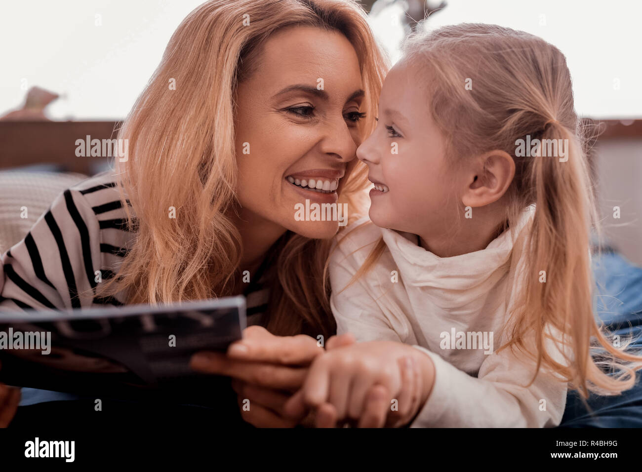 Beautiful daughter. Happy inspired lady looking at daughter while ...