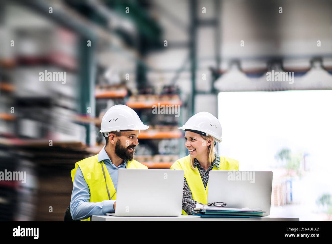 A portrait of an industrial man and woman engineer with laptop in a ...