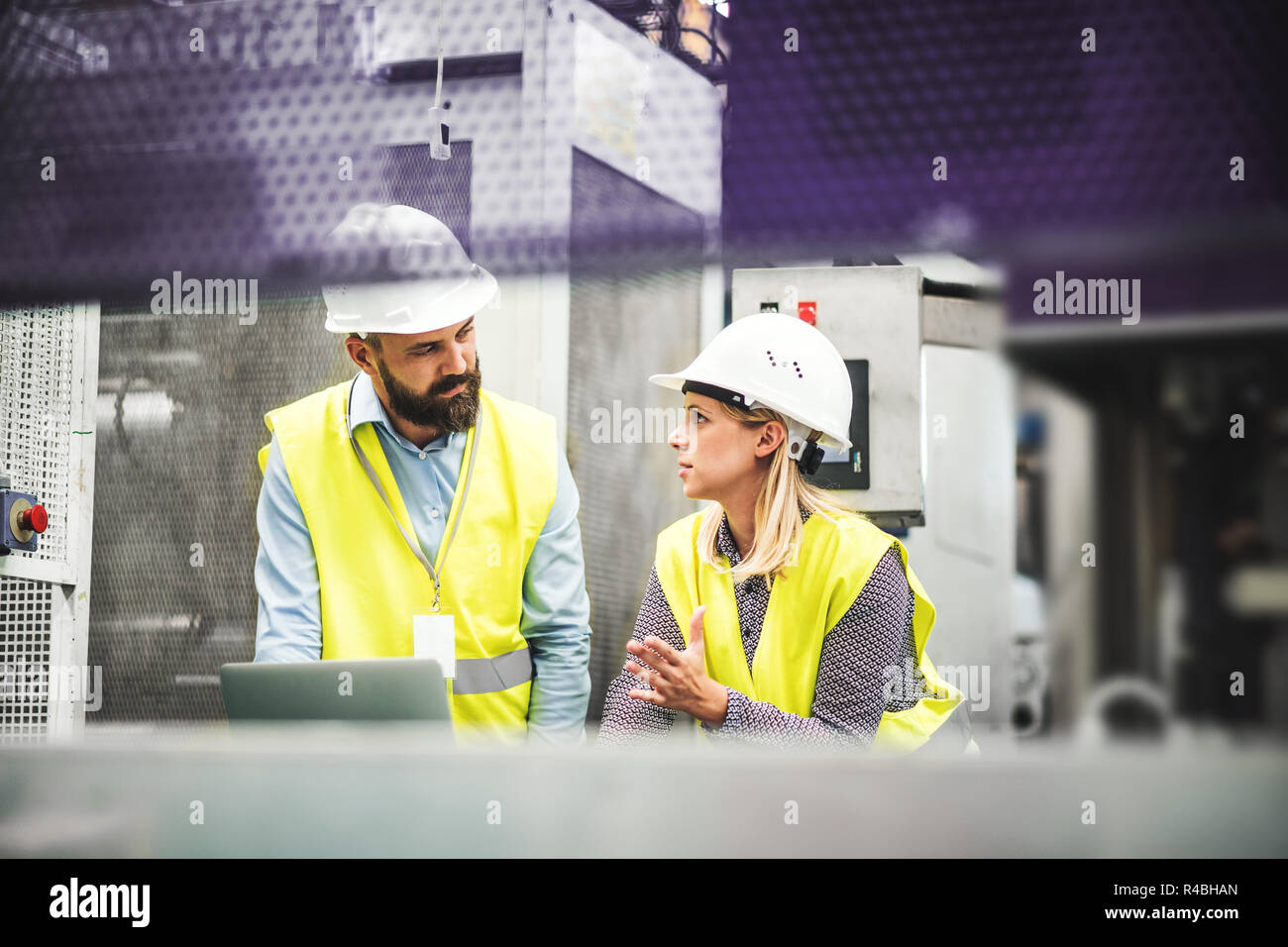 A portrait of an industrial man and woman engineer with laptop in a ...