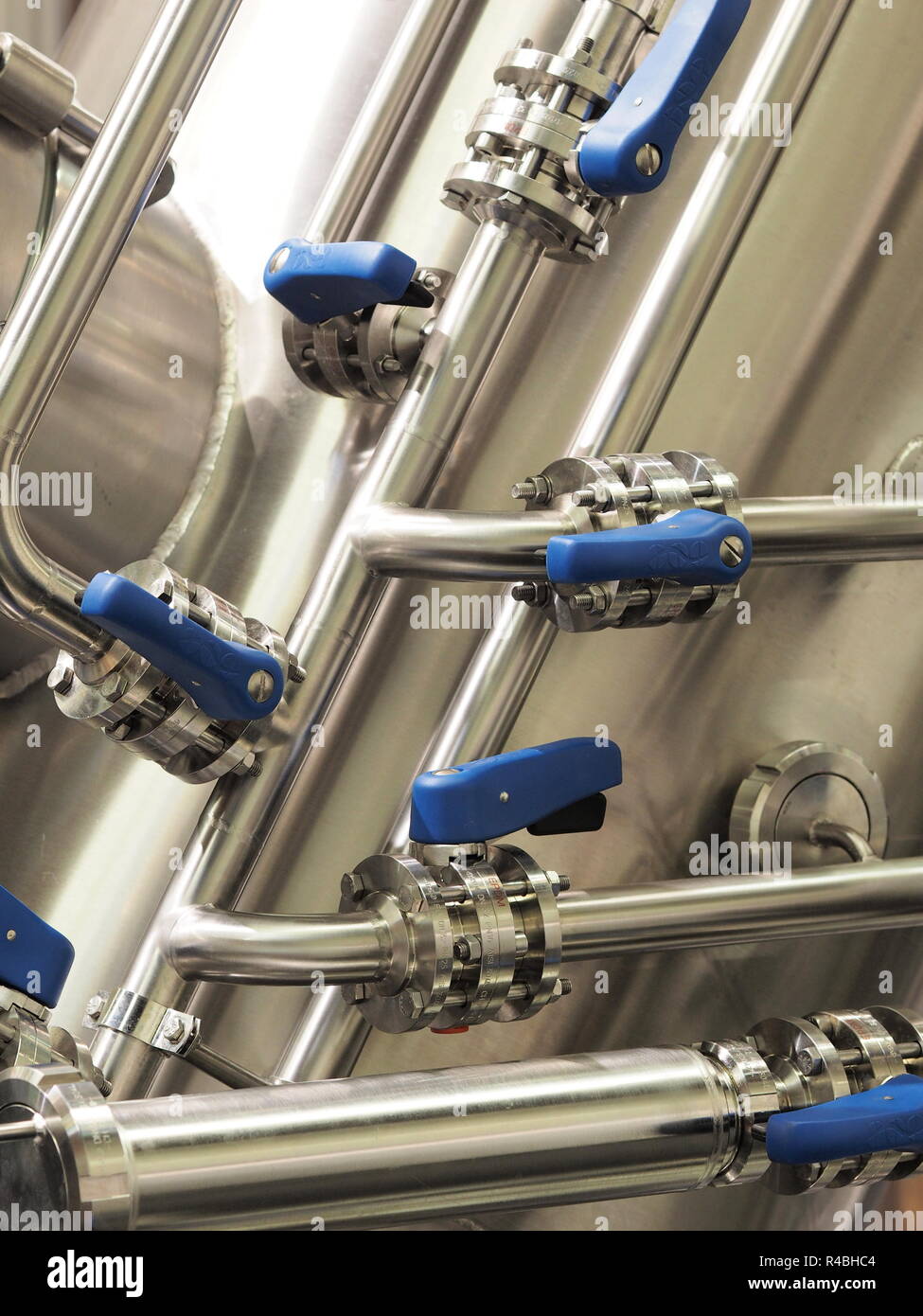 Industrial stainless steel pipe work with valves and blue handles Stock ...