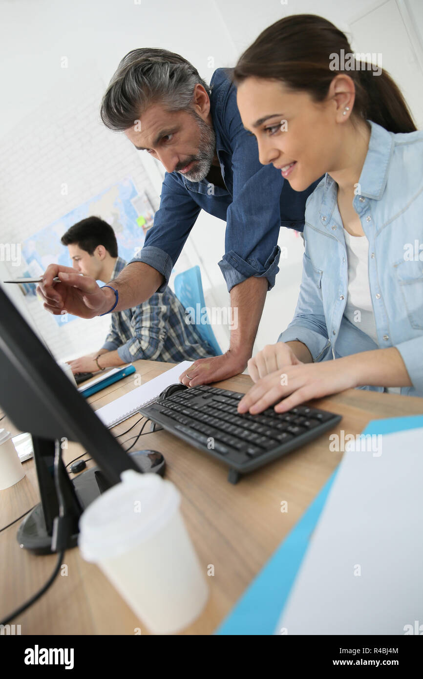 Teacher with young people in computing class Stock Photo - Alamy