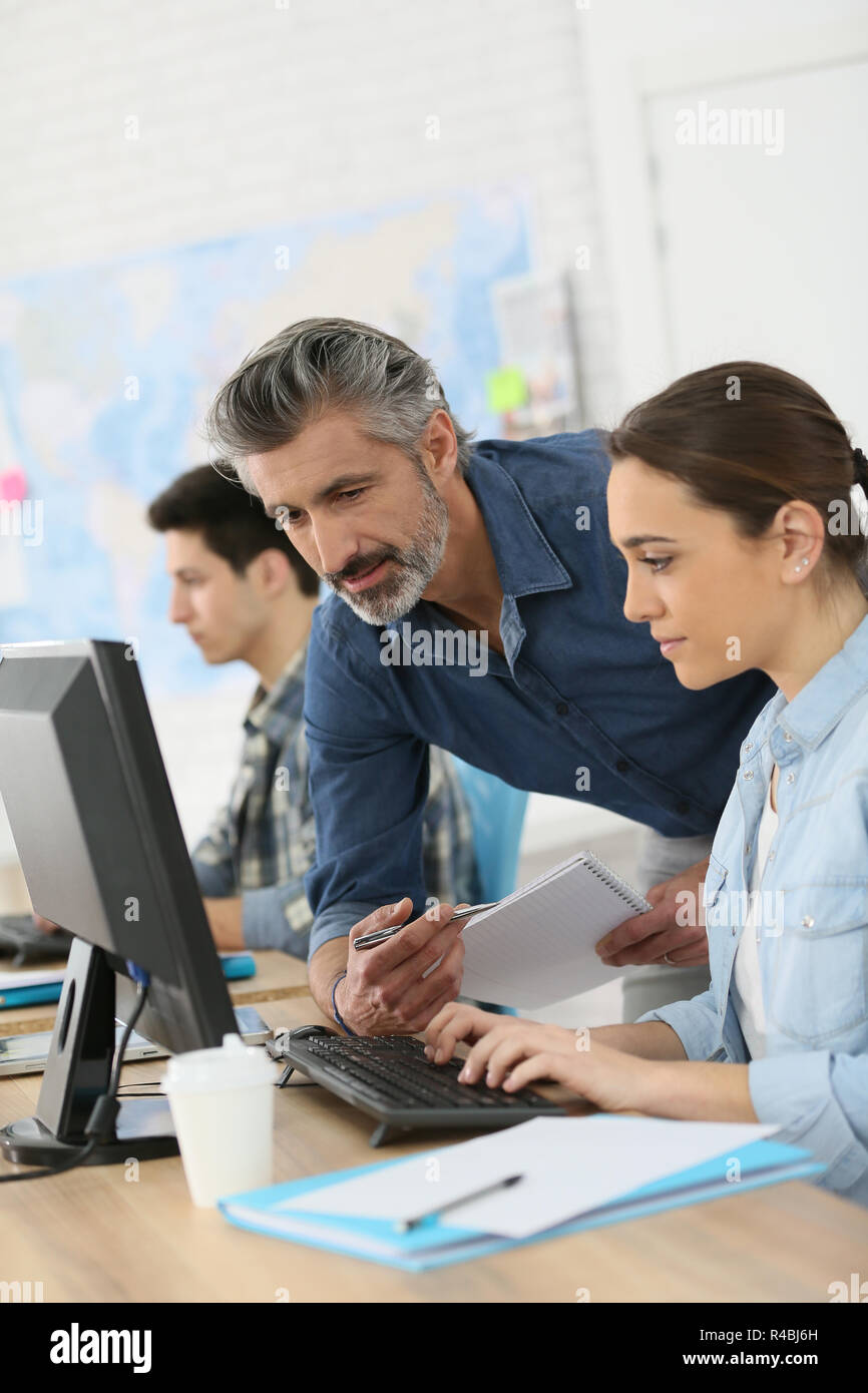 Trainer with student working on desktop computer Stock Photo - Alamy