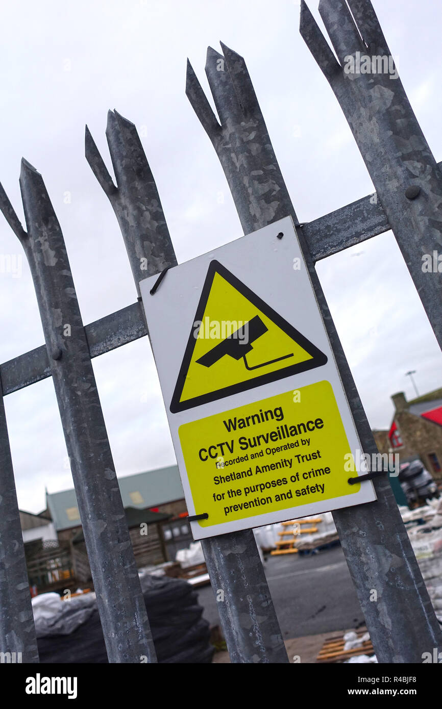 Surveillance sign on spiked fence warning of CCTV Stock Photo - Alamy