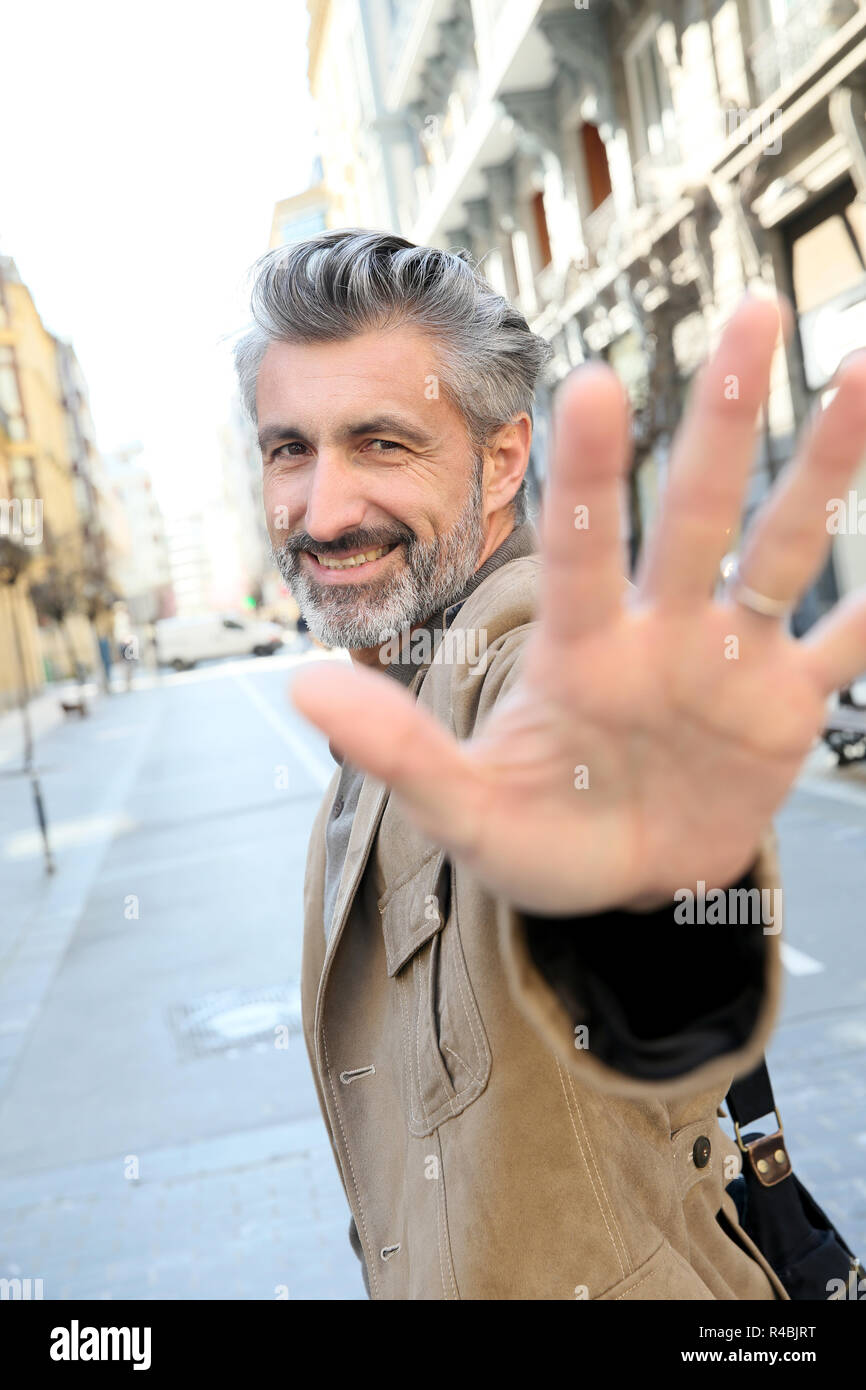 Handsome middle-aged man showing hand to camera Stock Photo - Alamy