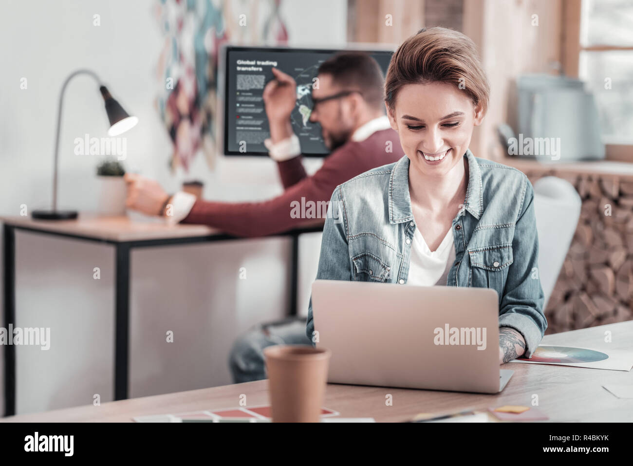 Lets chat. Kind young female person looking at screen of laptop while ...