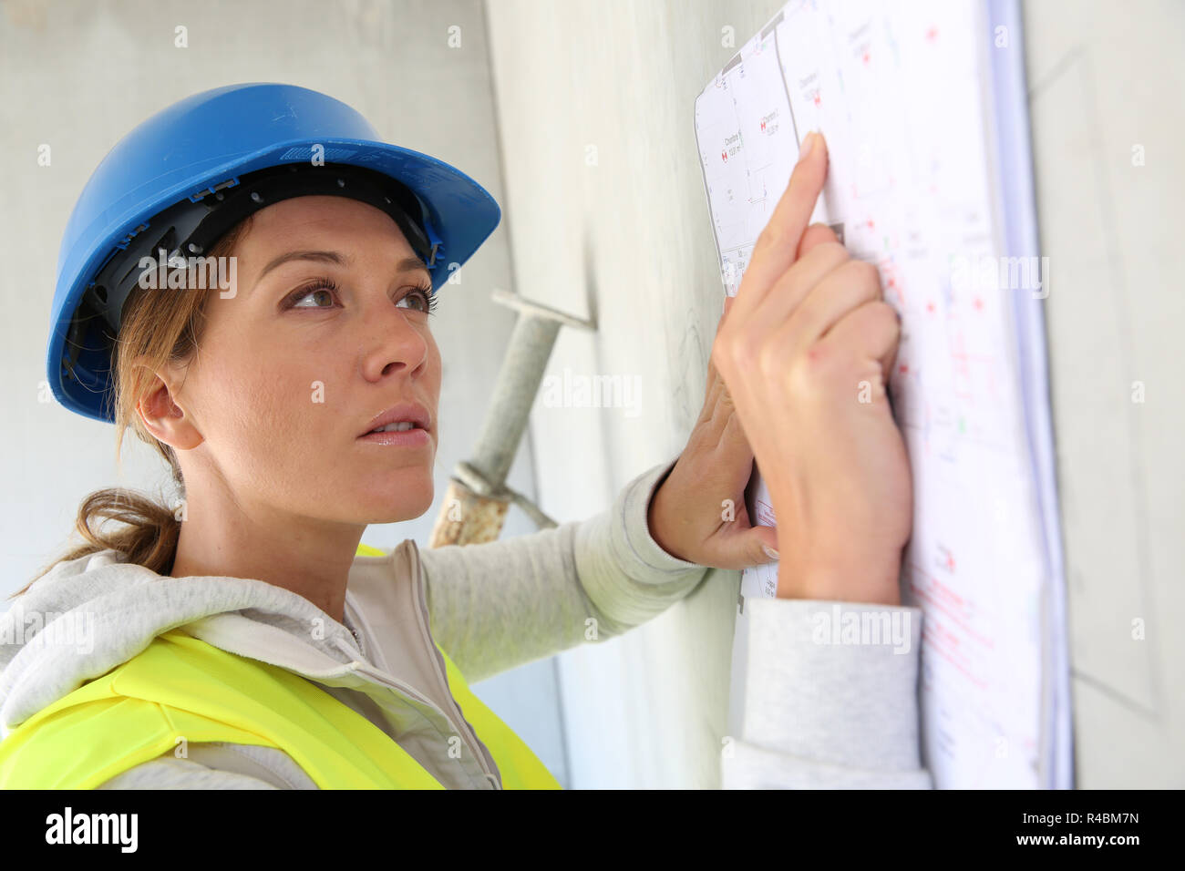 Woman architect reading construction plan Stock Photo - Alamy