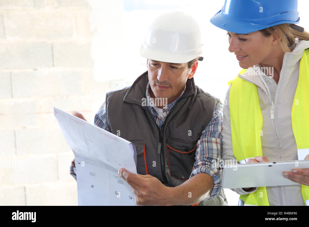 Engineers on building site checking plans Stock Photo - Alamy