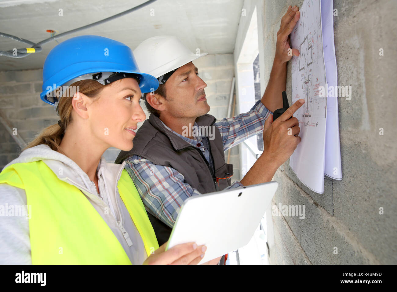 Engineers on building site checking plans Stock Photo - Alamy