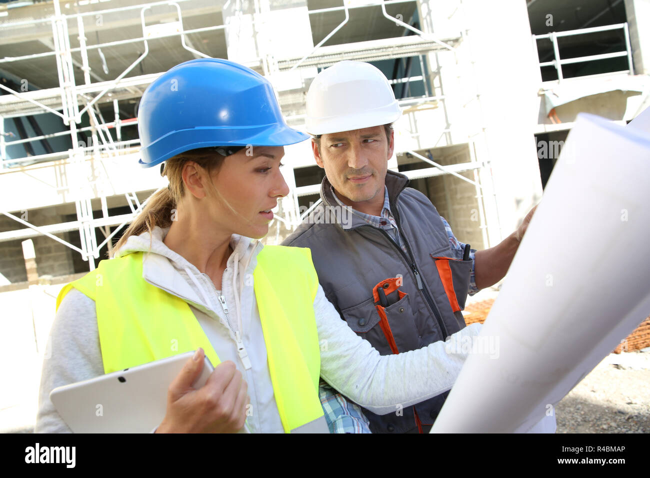 Engineers on building site checking plans Stock Photo - Alamy
