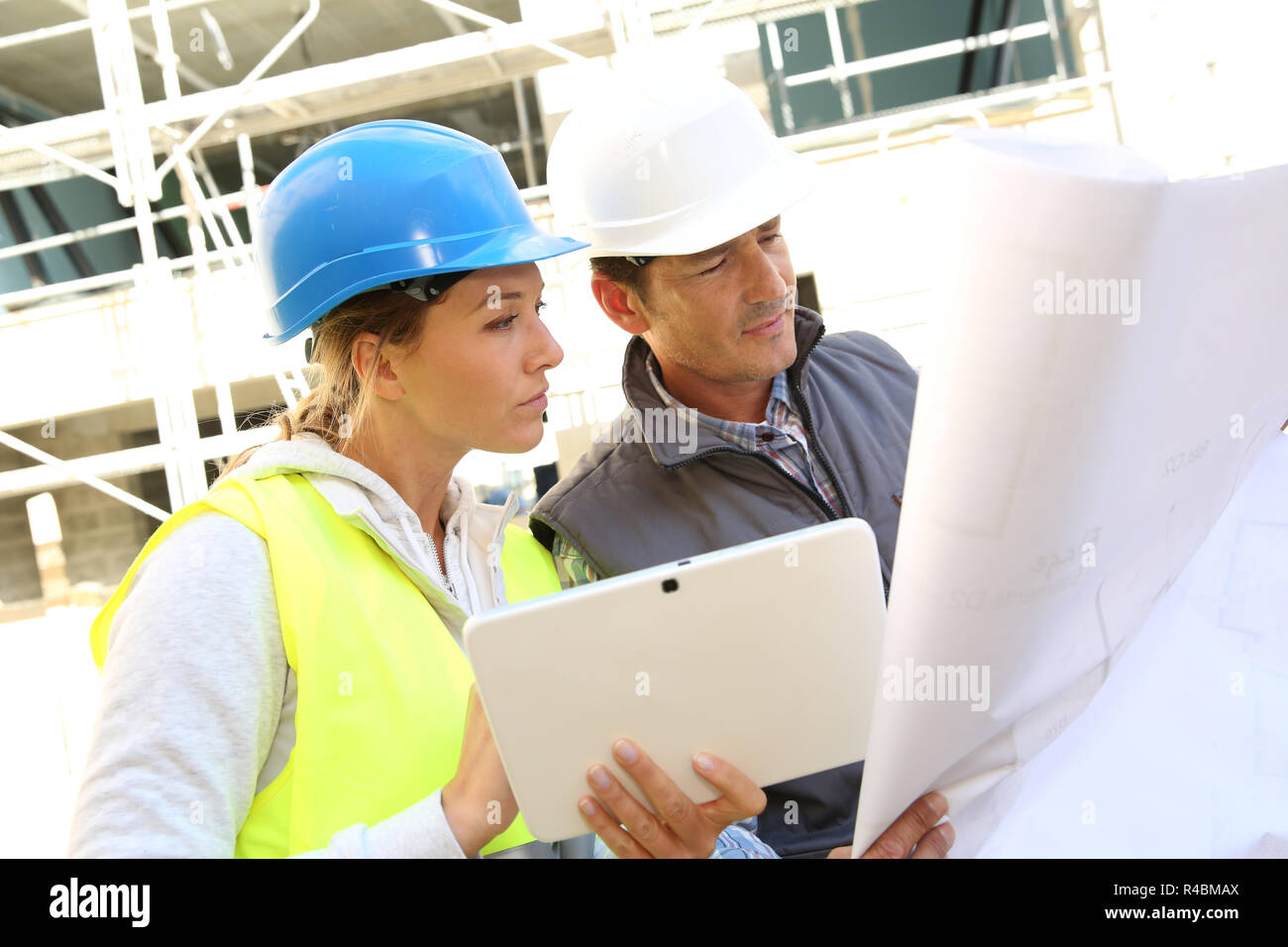 Engineers on building site checking plans Stock Photo - Alamy