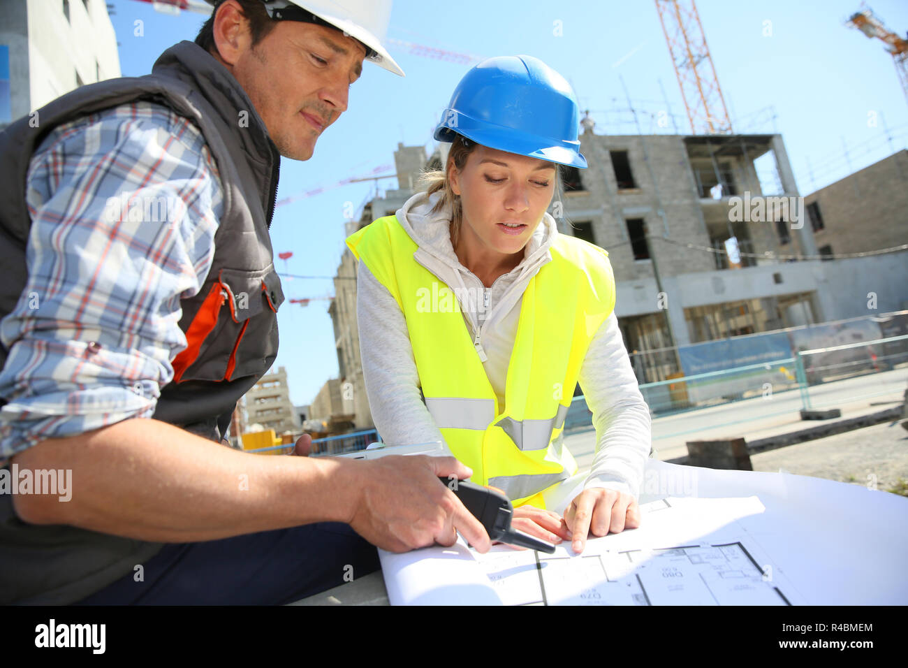 Engineers on building site checking plans Stock Photo - Alamy