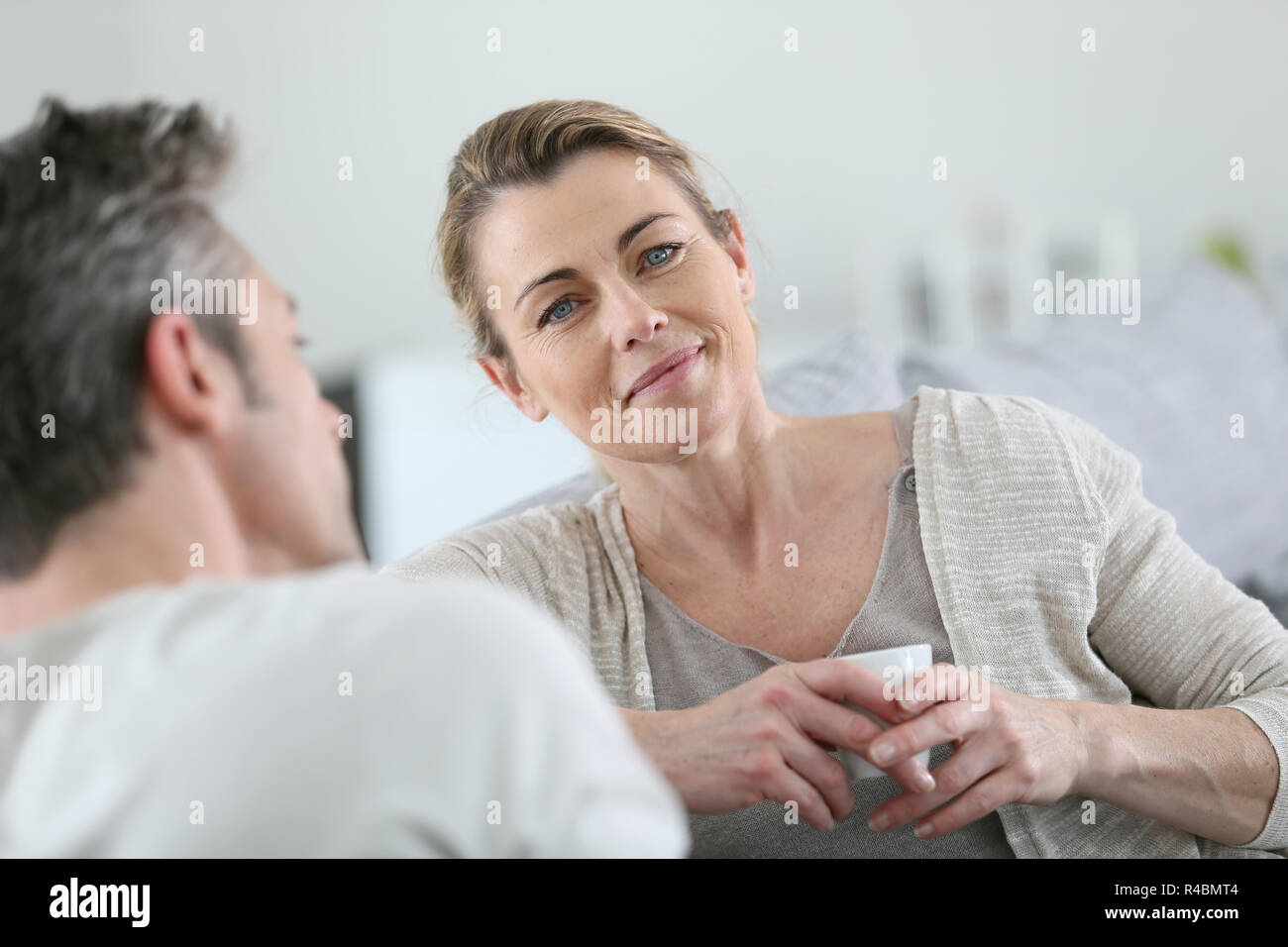 Mature couple talking together in sofa Stock Photo - Alamy