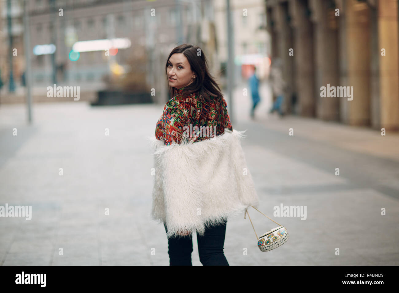 Young stylish woman in fur coat walking street Stock Photo - Alamy