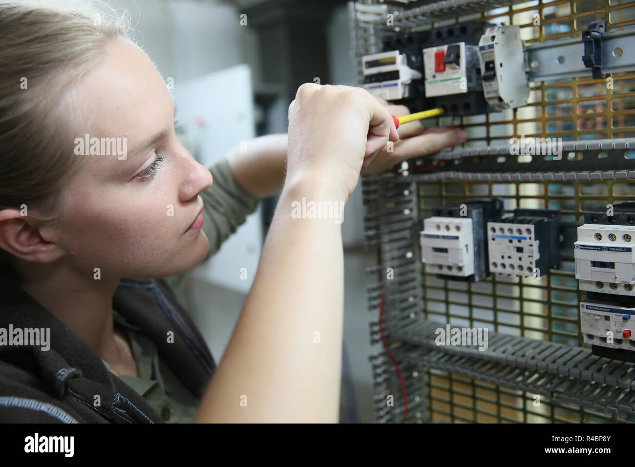 Young woman in professional training setting up electrical circuit ...