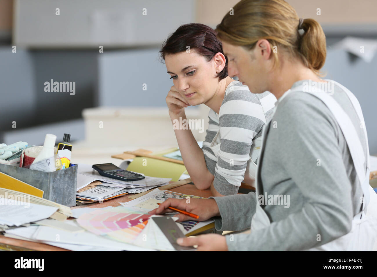Painter with apprentice showing colour sample for next site Stock Photo ...
