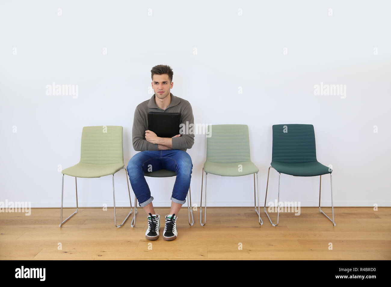 Young man in waiting room for job interview Stock Photo - Alamy