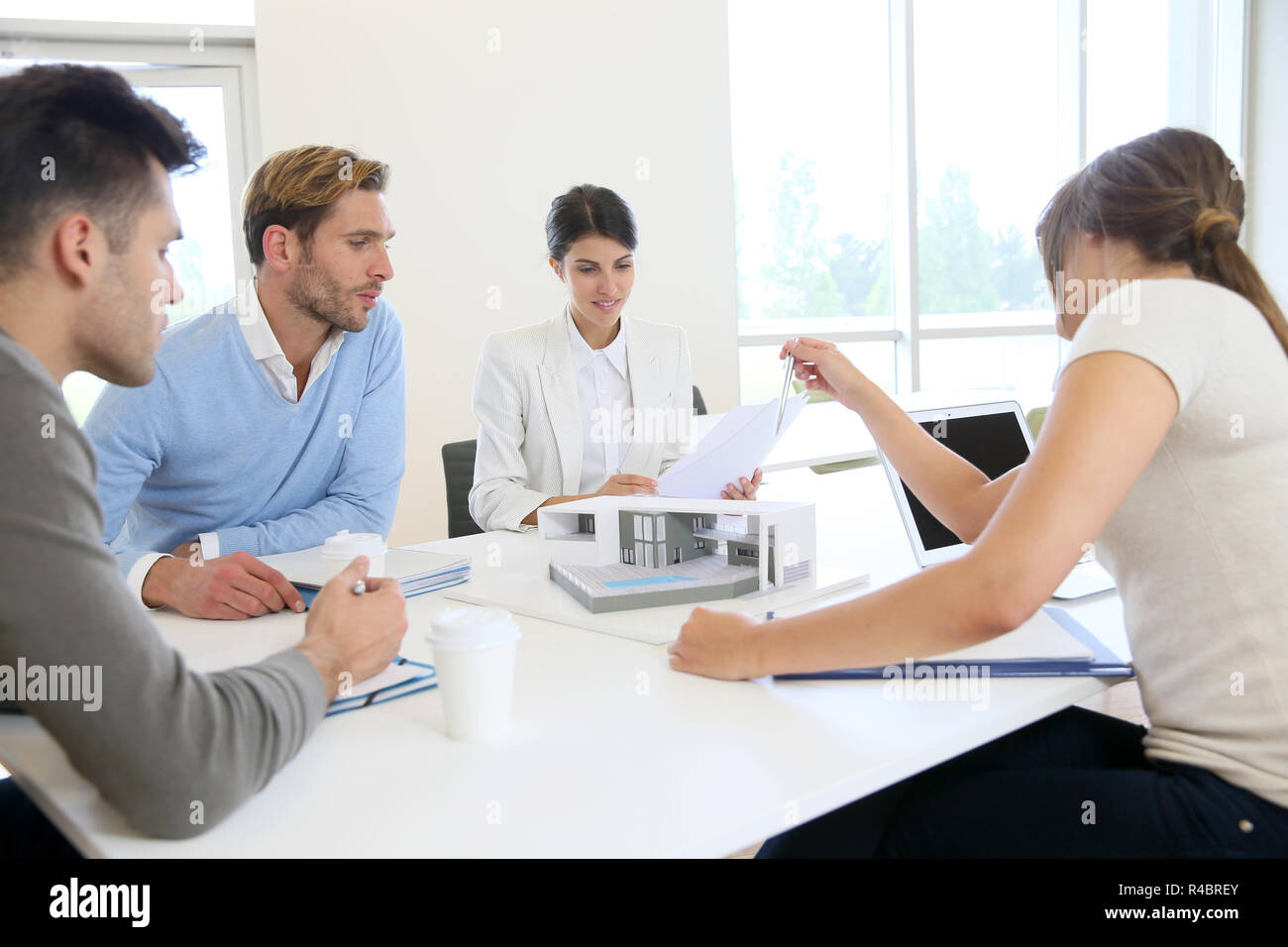 Team of architects meeting around table to talk about project Stock ...
