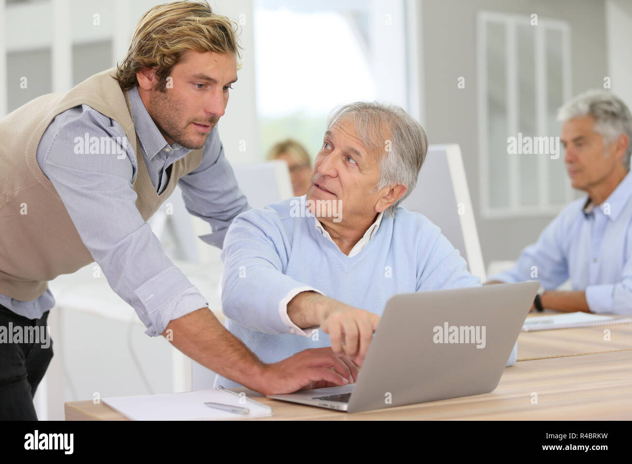 Senior man attending business class with trainer Stock Photo - Alamy