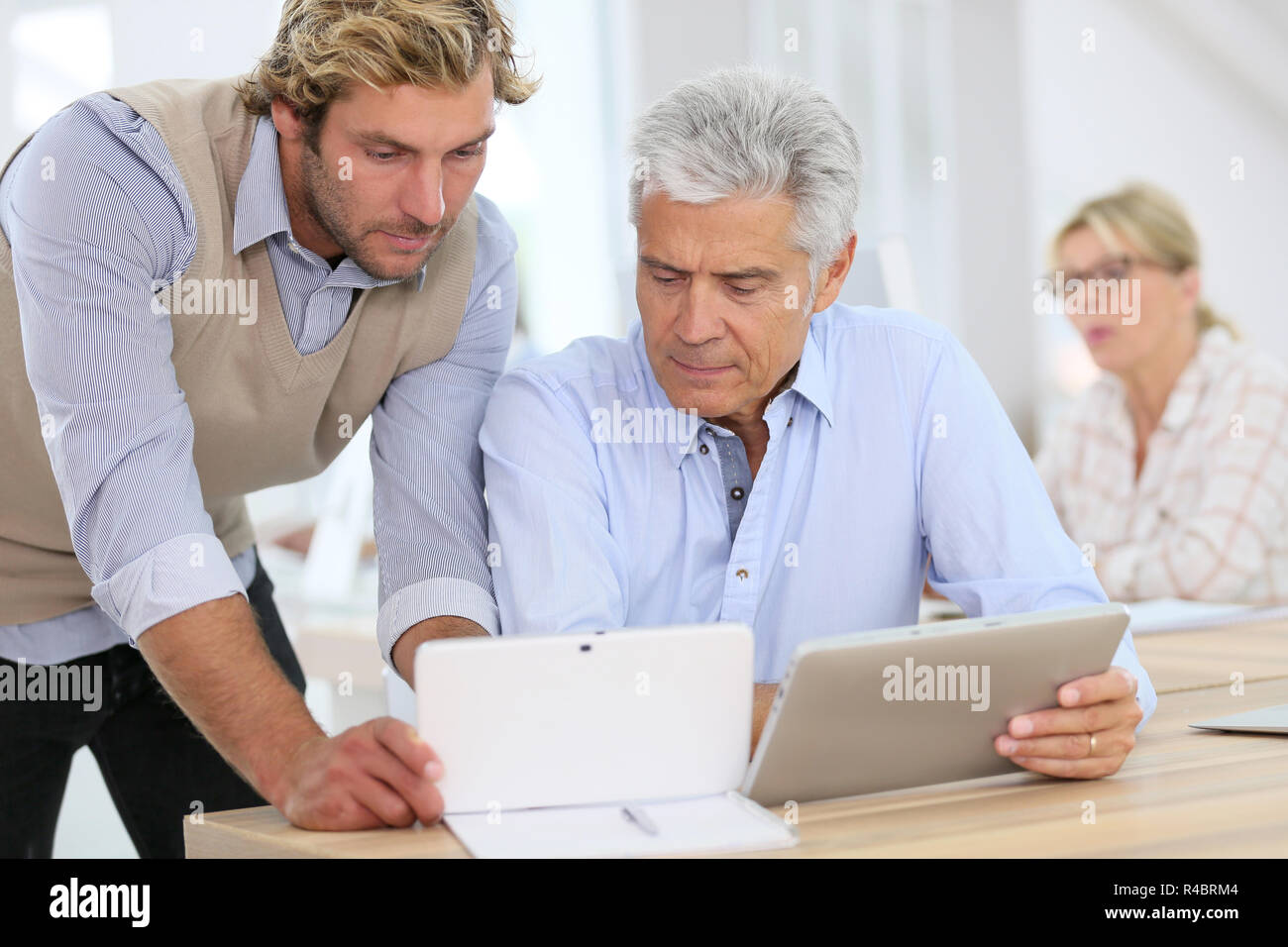 Senior man attending business class with trainer Stock Photo - Alamy