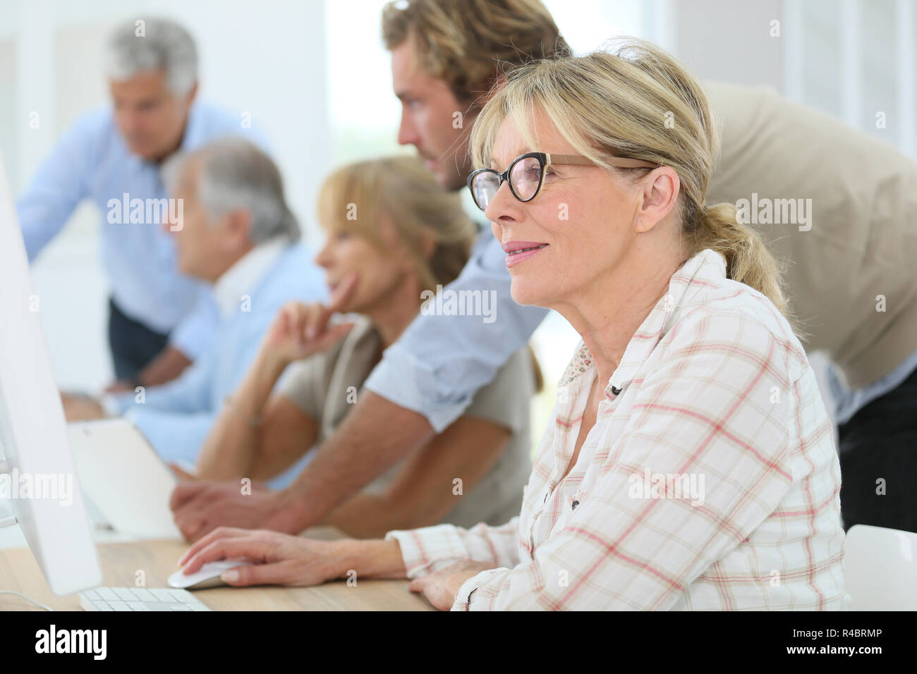 Senior woman in training business class Stock Photo - Alamy