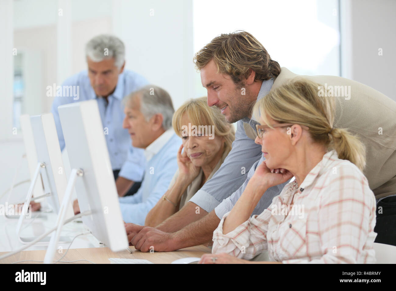 Group of senior people attending computing class Stock Photo - Alamy