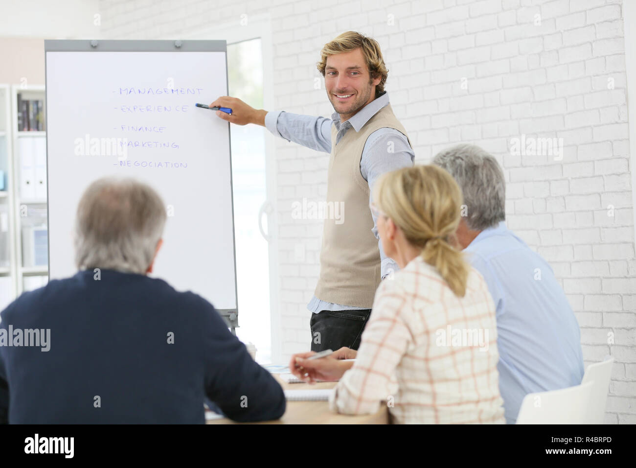 Business instructor leading meeting with senior training group Stock ...