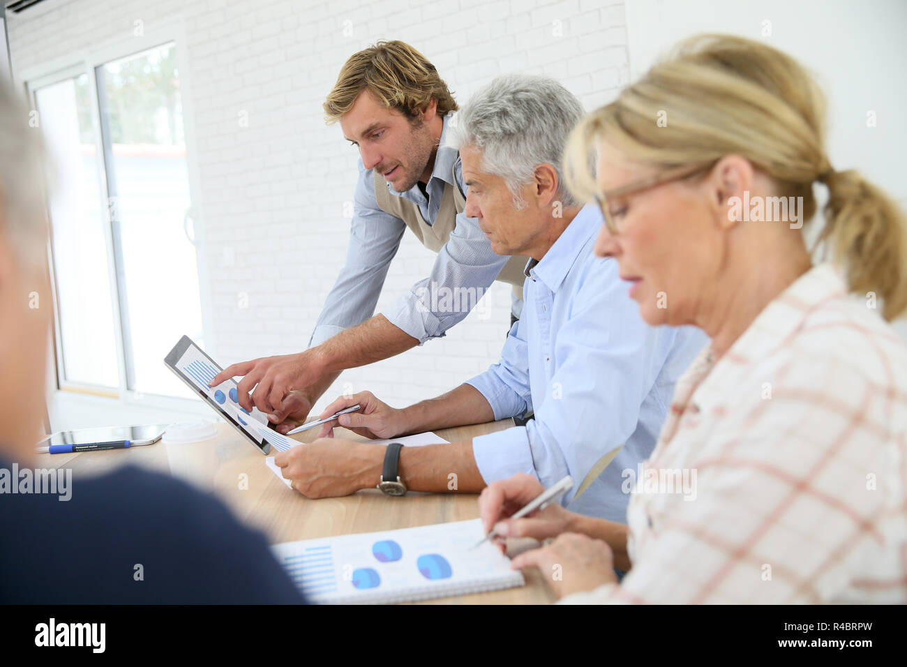 Business instructor with group of senior people Stock Photo - Alamy